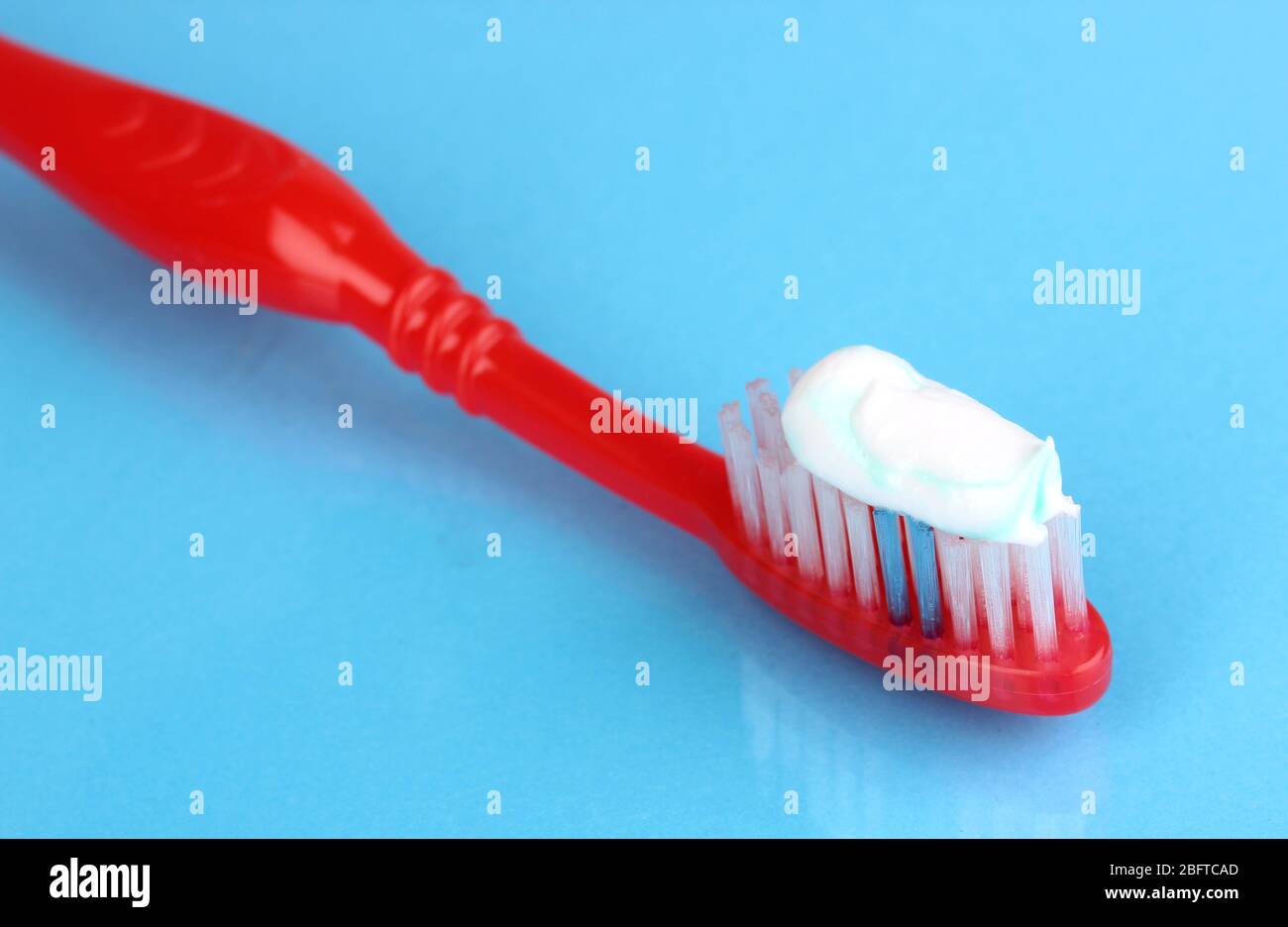 Toothbrush with paste on blue background Stock Photo - Alamy
