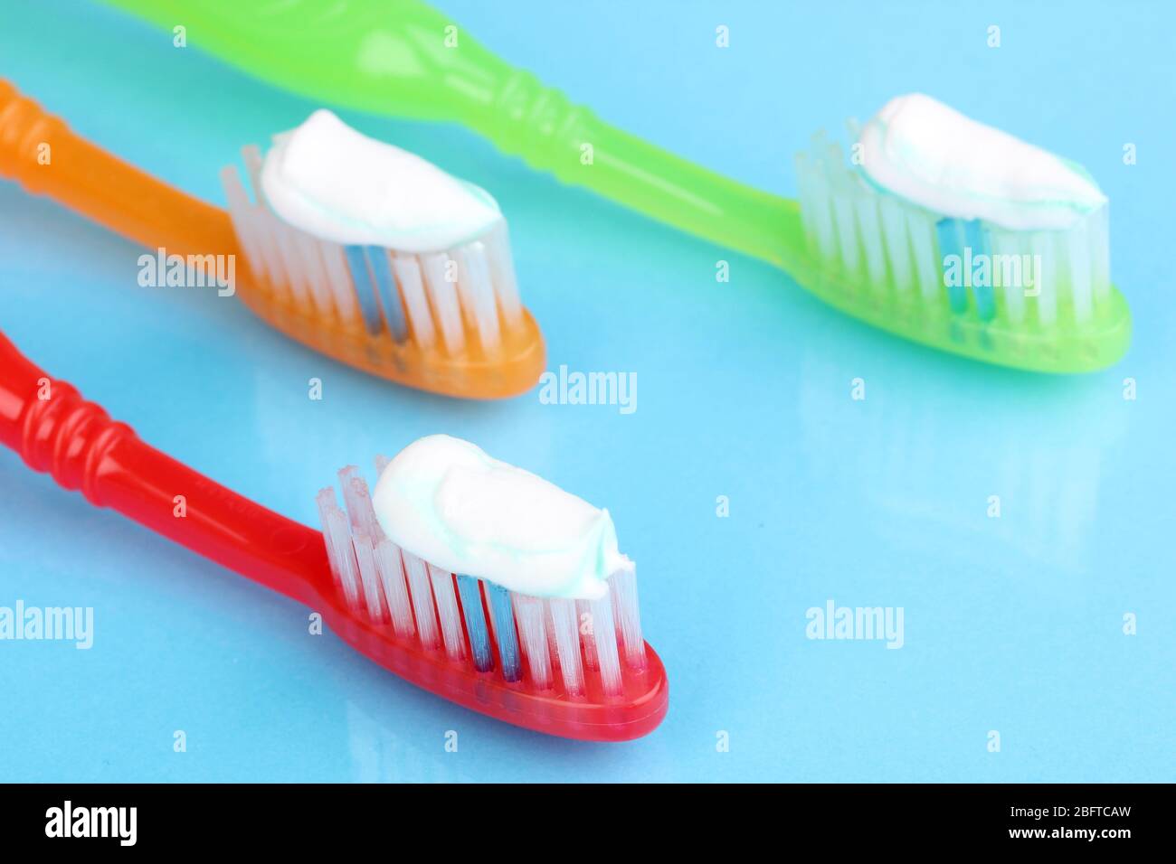 Toothbrushes with paste on blue background Stock Photo - Alamy