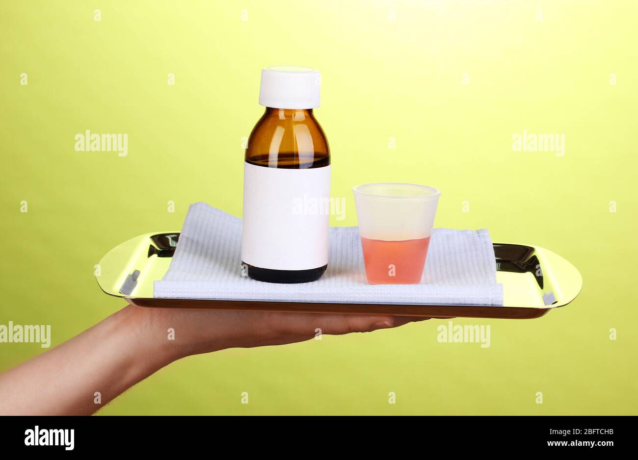 Hand holding tray with medicines on green background Stock Photo - Alamy