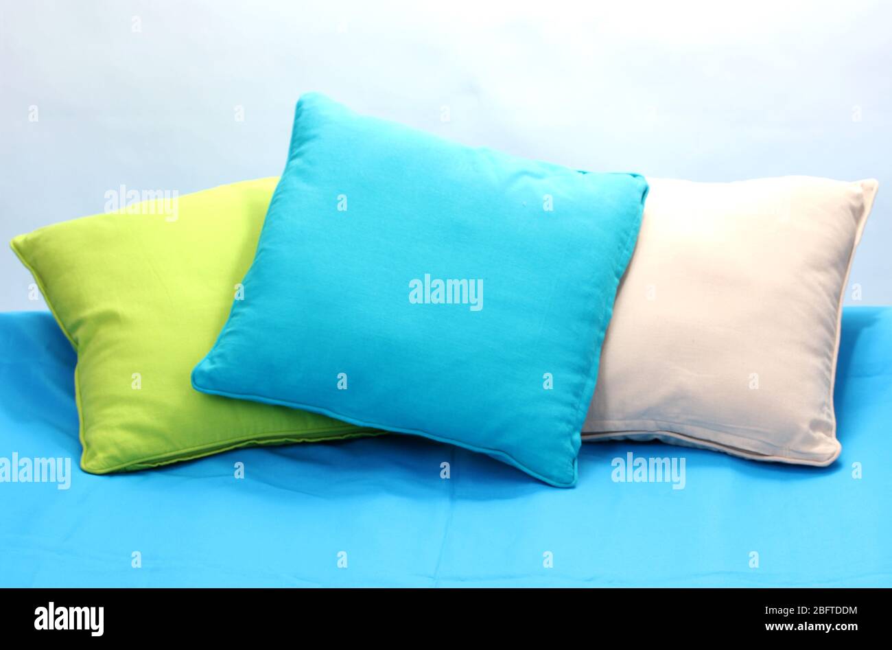 bright pillows on bed on white background Stock Photo - Alamy