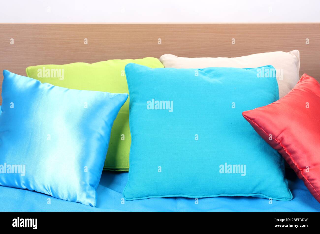 bright pillows on bed on white background Stock Photo - Alamy