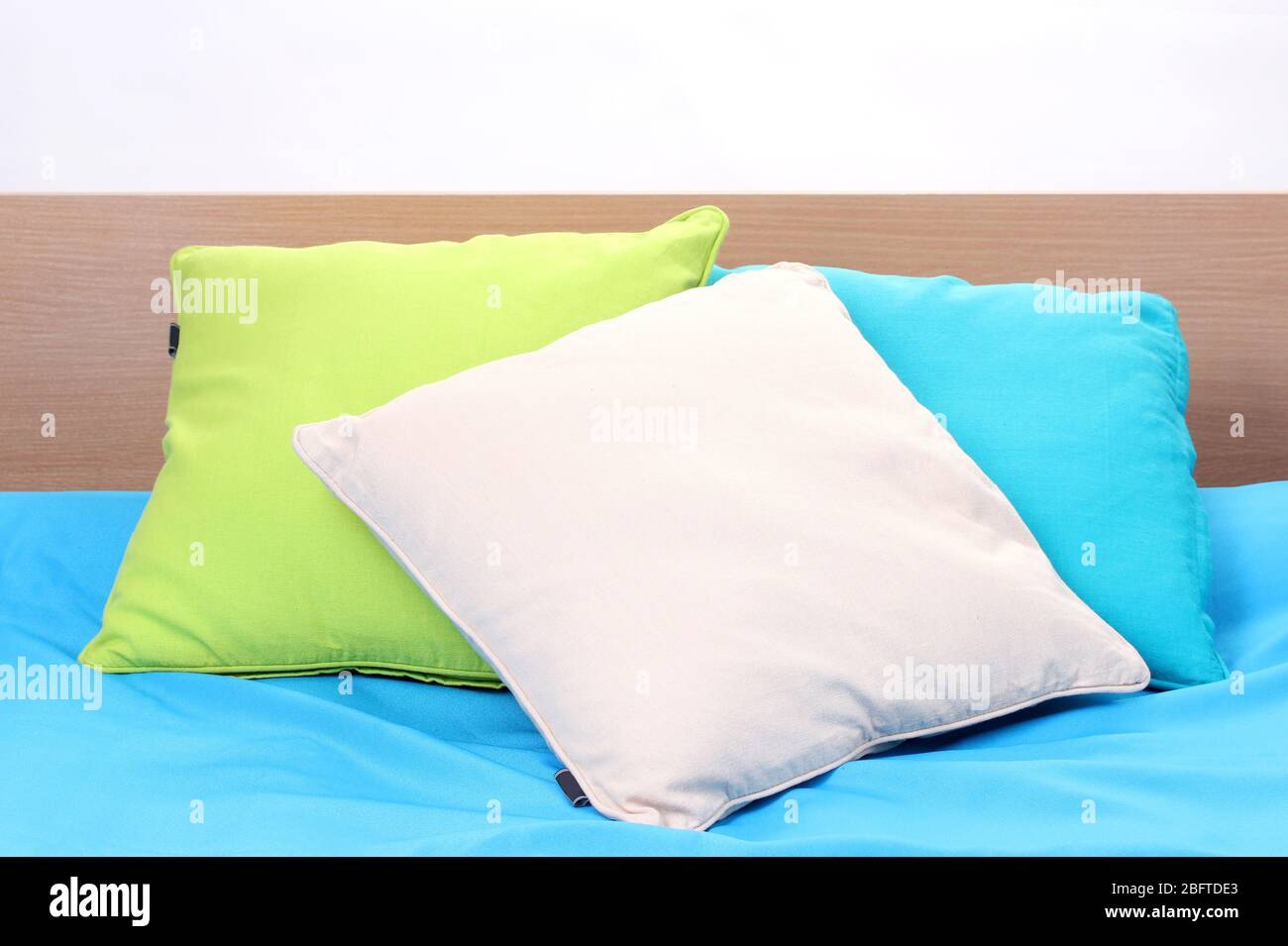 bright pillows on bed on white background Stock Photo - Alamy