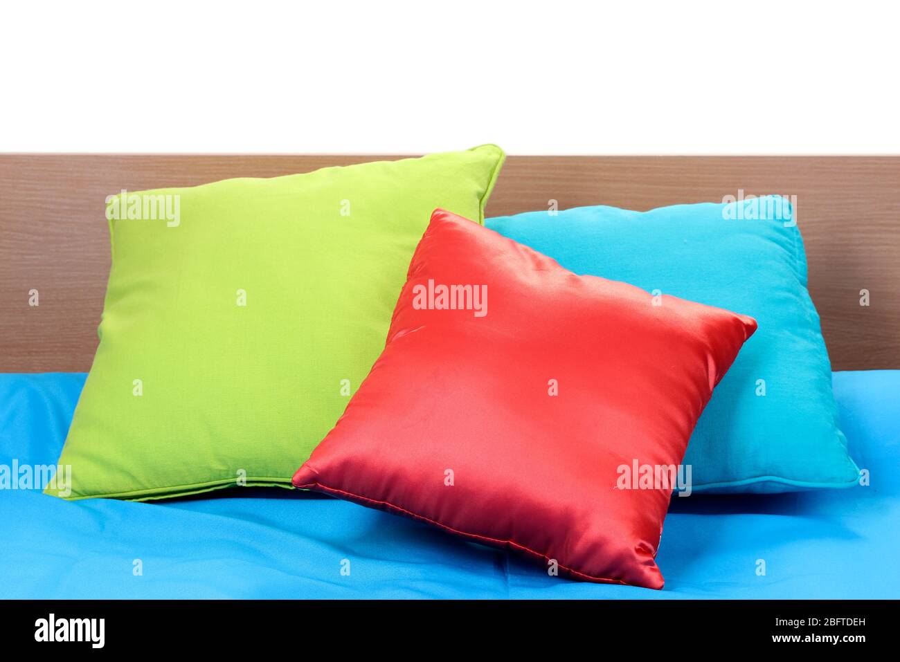 bright pillows on bed on white background Stock Photo - Alamy