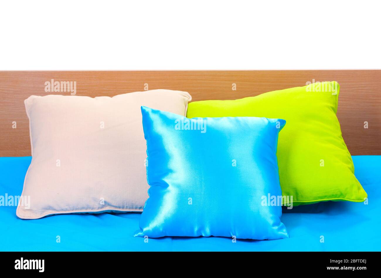 bright pillows on bed on white background Stock Photo - Alamy