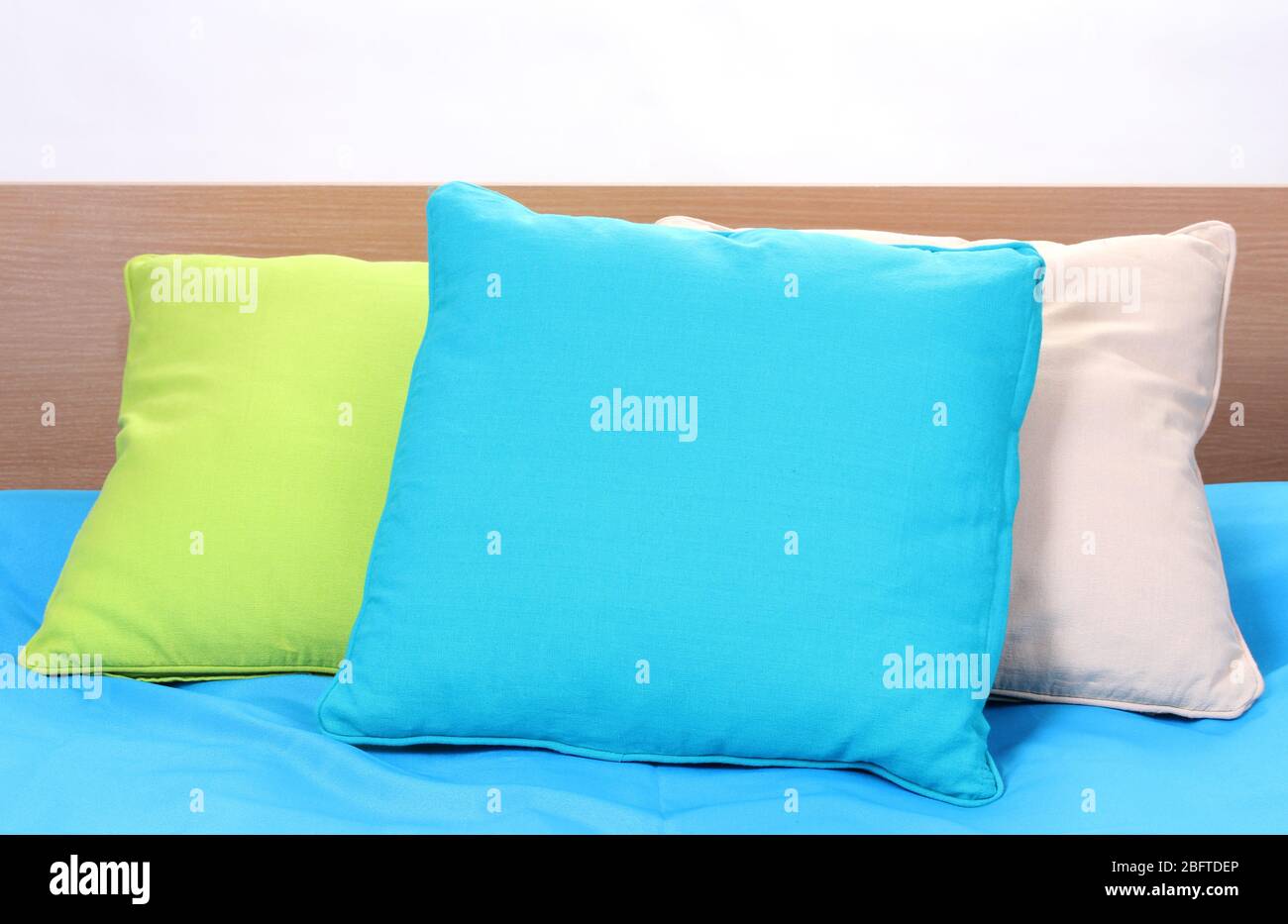 bright pillows on bed on white background Stock Photo - Alamy