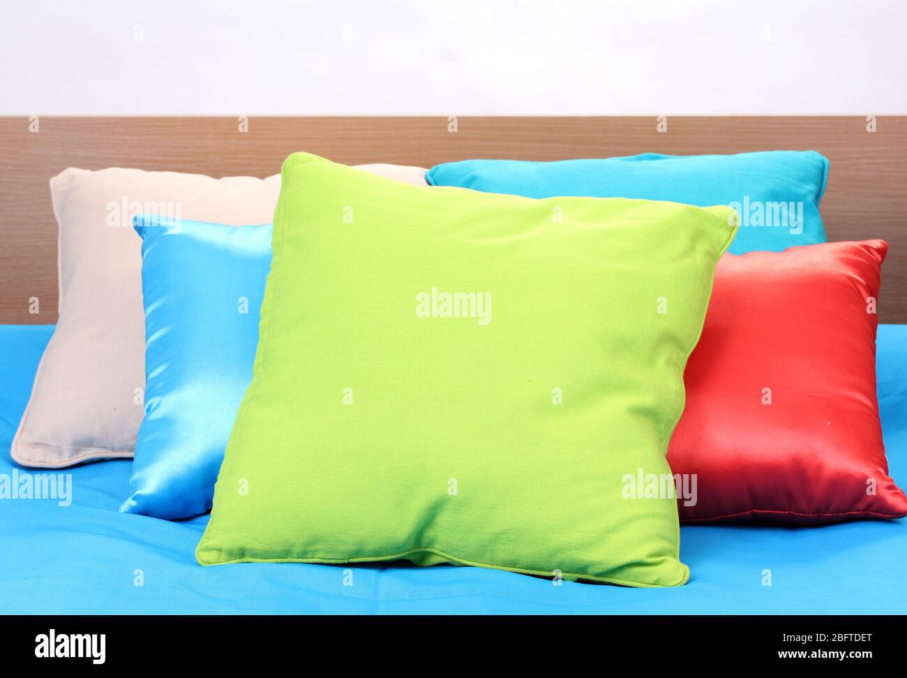 bright pillows on bed on white background Stock Photo - Alamy