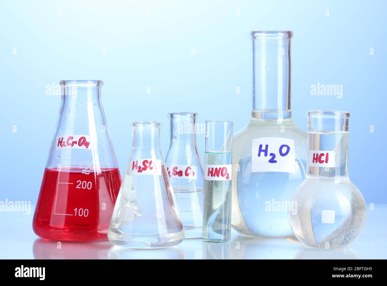 Test-tubes with various acids on blue background Stock Photo - Alamy