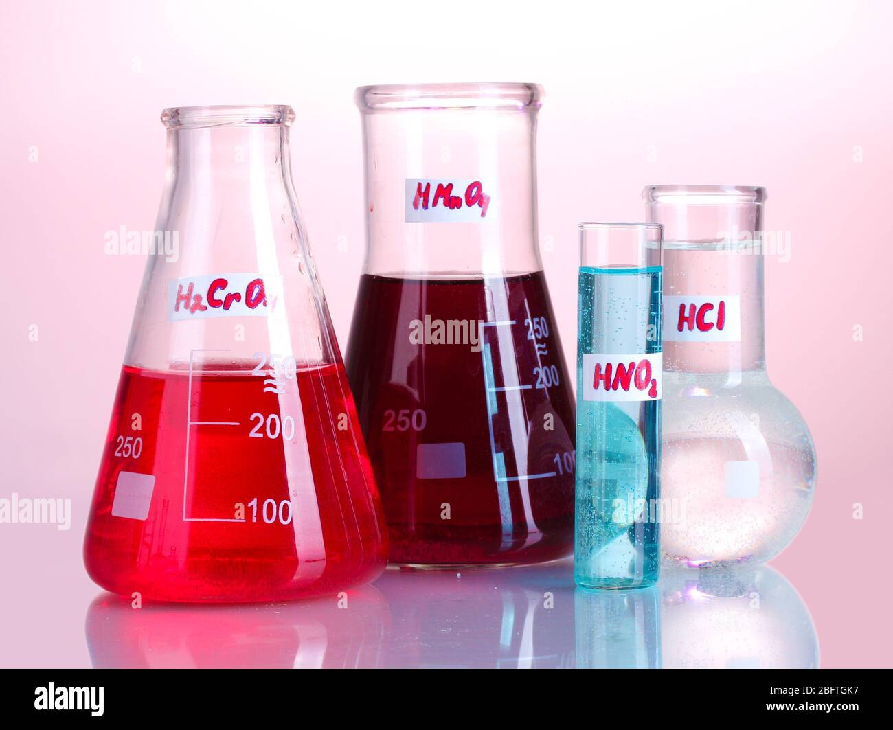 Test-tubes with various acids and chemicals on pink background Stock ...