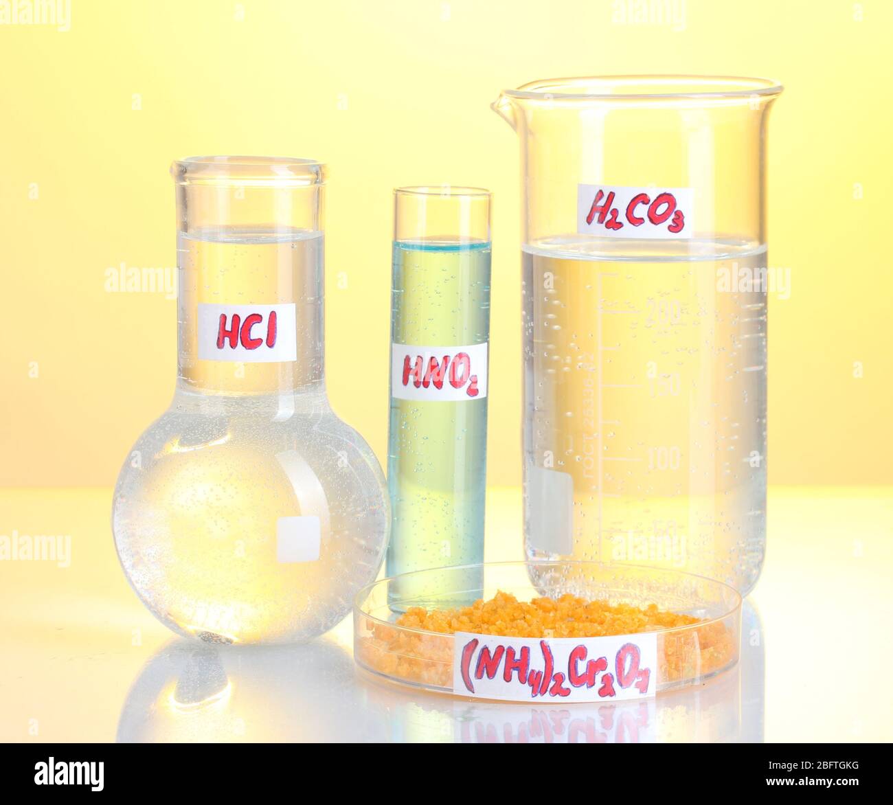 Test-tubes with various acids and chemicals on yellow background Stock ...