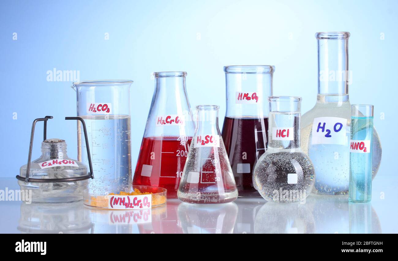 Test-tubes with various acids and chemicals on blue background Stock ...