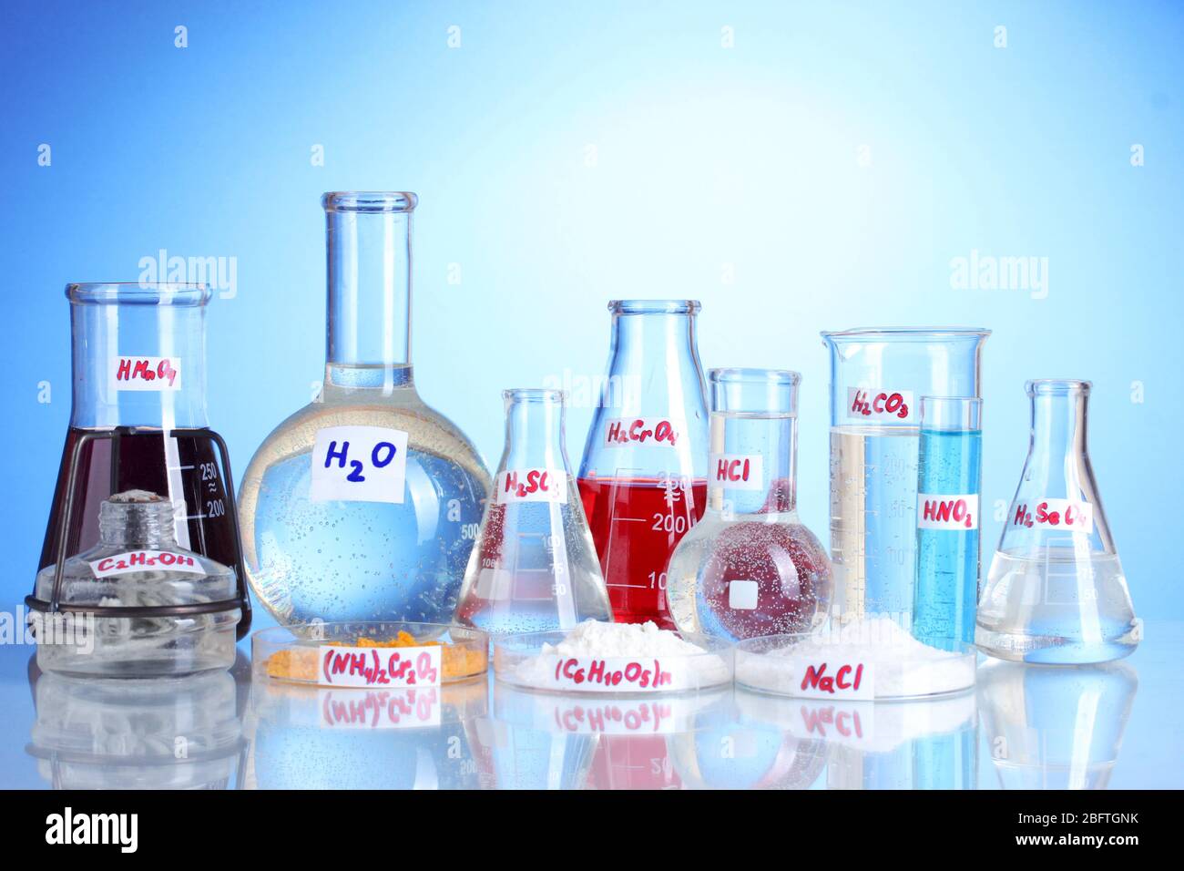 Test-tubes with various acids and chemicals on blue background Stock ...