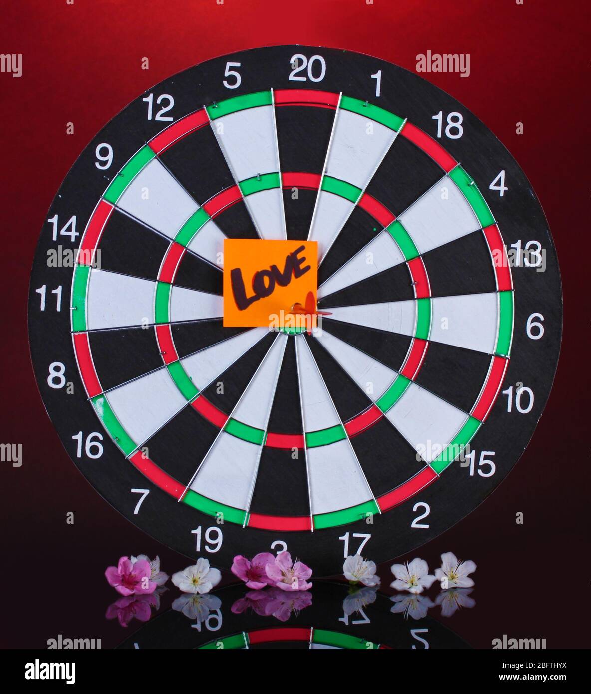 Darts with a sticker symbolizing love on colorful background Stock ...