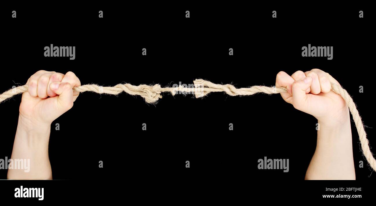 Breaking rope in hands isolated on black Stock Photo - Alamy