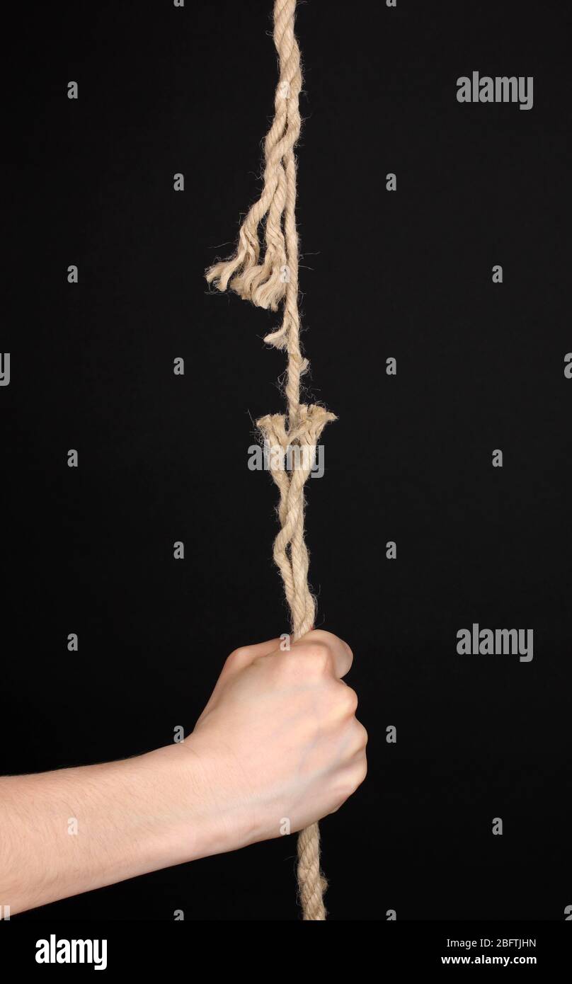 Breaking rope and hand isolated on black Stock Photo - Alamy
