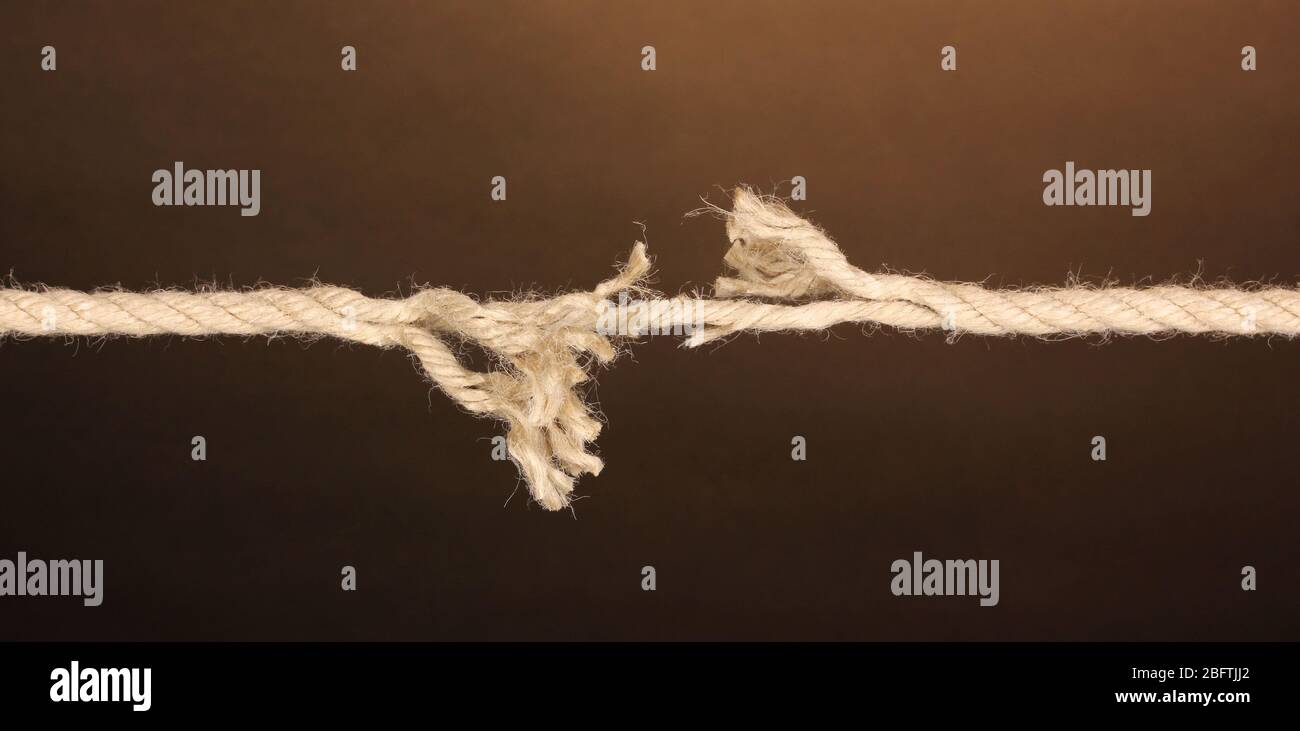 Breaking rope on brown background Stock Photo - Alamy