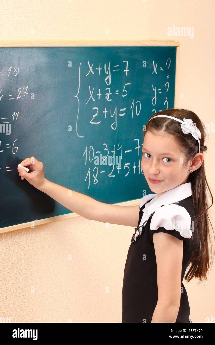 beautiful little girl writing on classroom board Stock Photo - Alamy