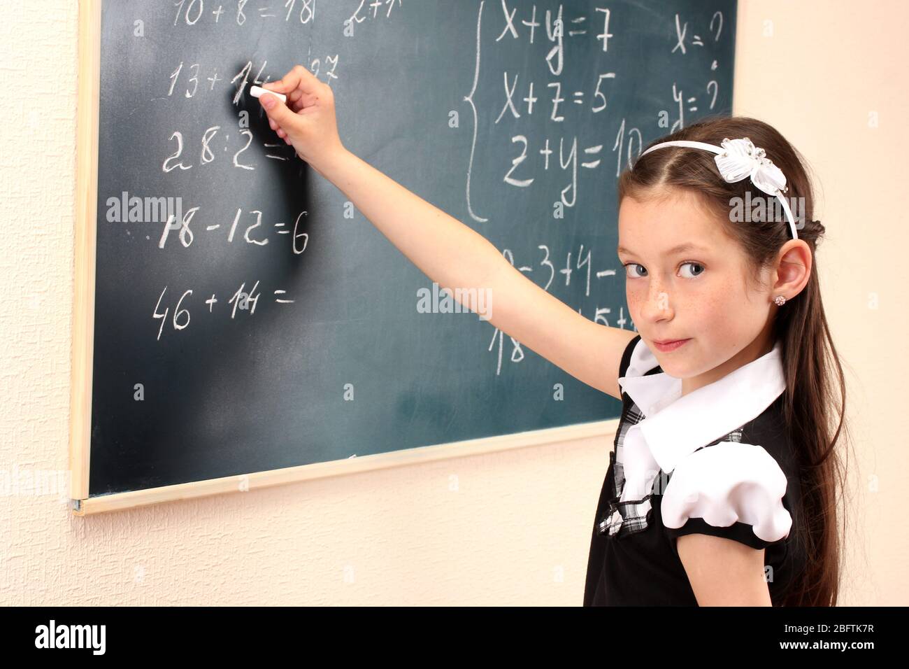 beautiful little girl writing on classroom board Stock Photo - Alamy
