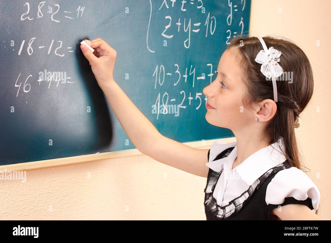 beautiful little girl writing on classroom board Stock Photo - Alamy
