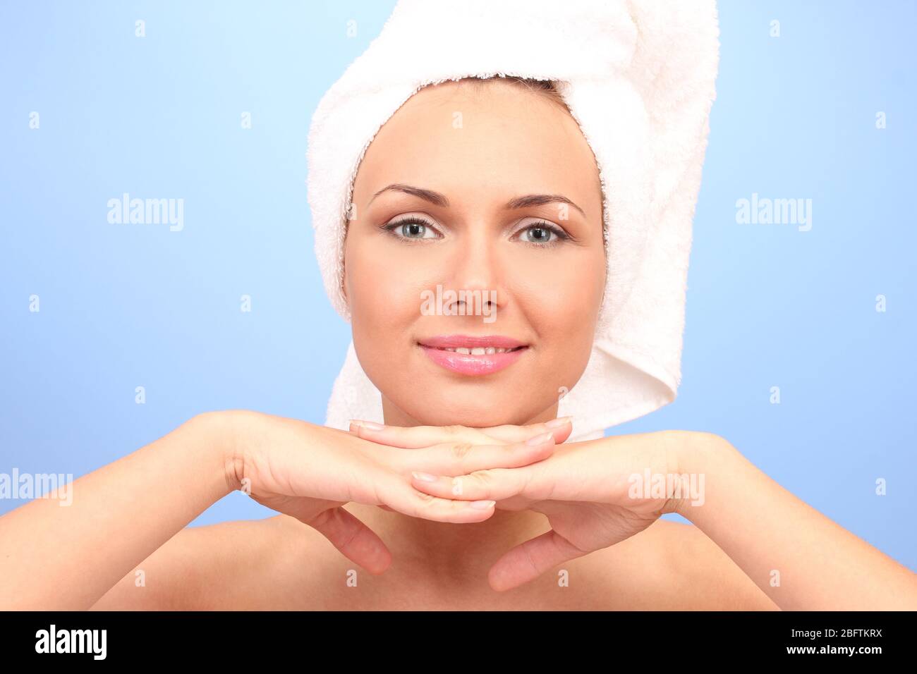 Beautiful young woman after shower with a towel on her head on blue ...