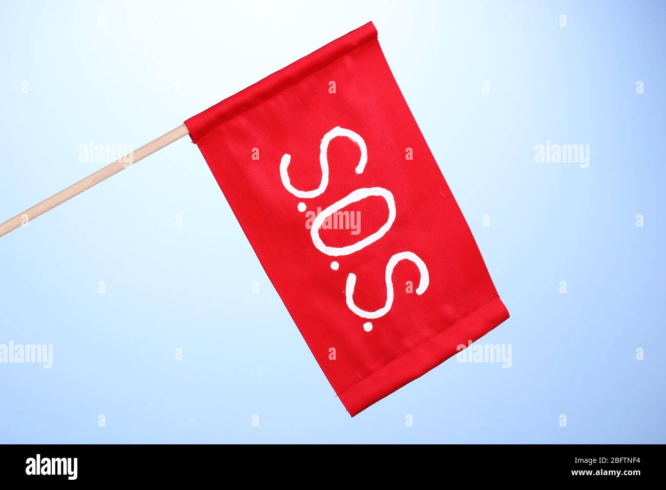 SOS signal written on red cloth on blue background Stock Photo - Alamy
