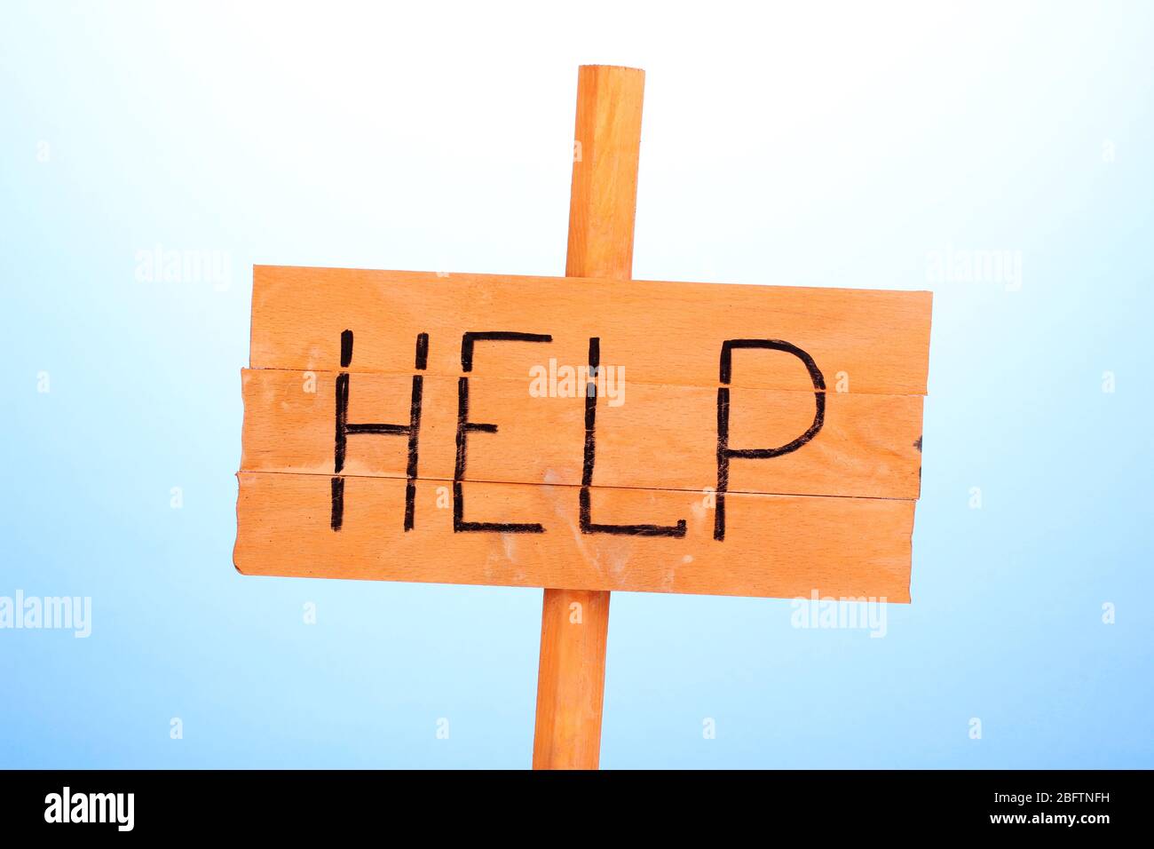 Help wooden board on blue background Stock Photo - Alamy