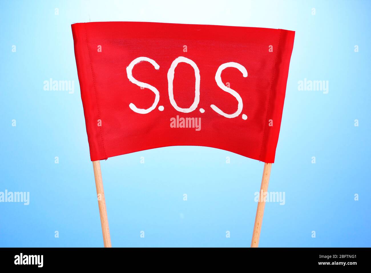 SOS signal written on red cloth on blue background Stock Photo - Alamy