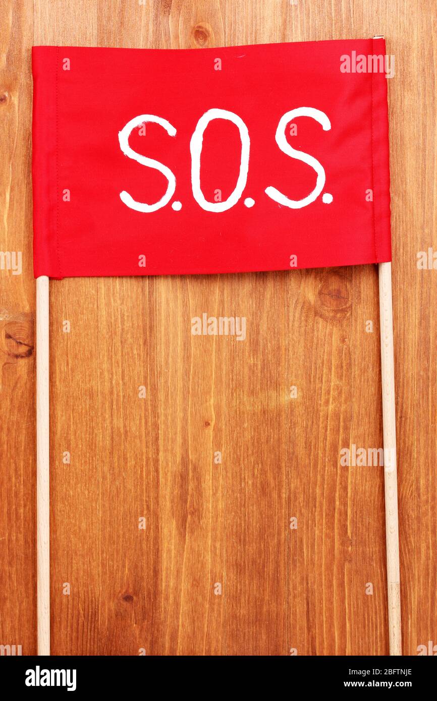 SOS signal written on red cloth on wooden background Stock Photo - Alamy