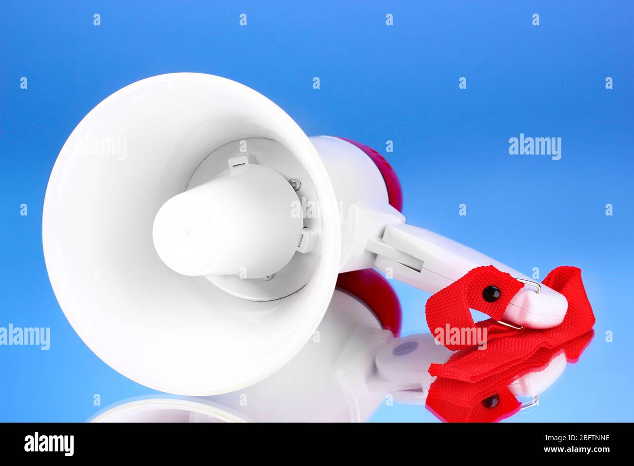 red and white megaphone on blue background Stock Photo - Alamy