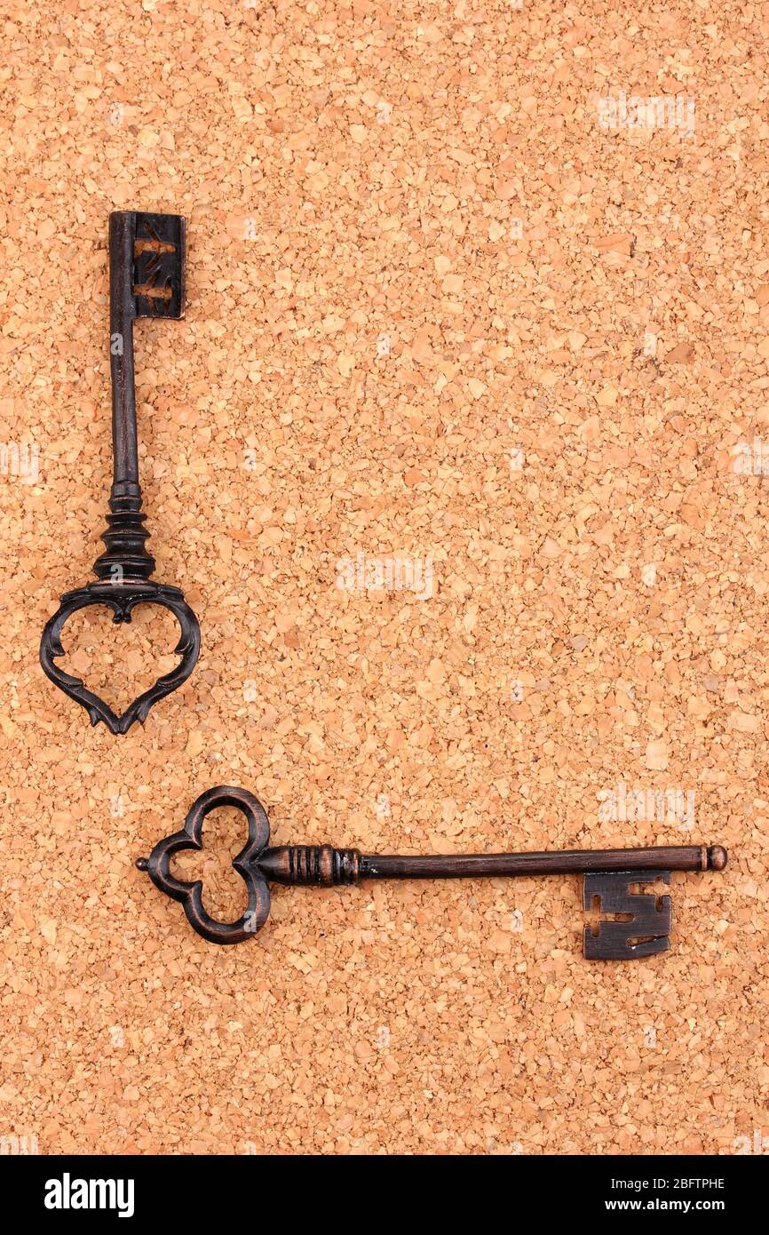 Two antique keys on cork background Stock Photo - Alamy