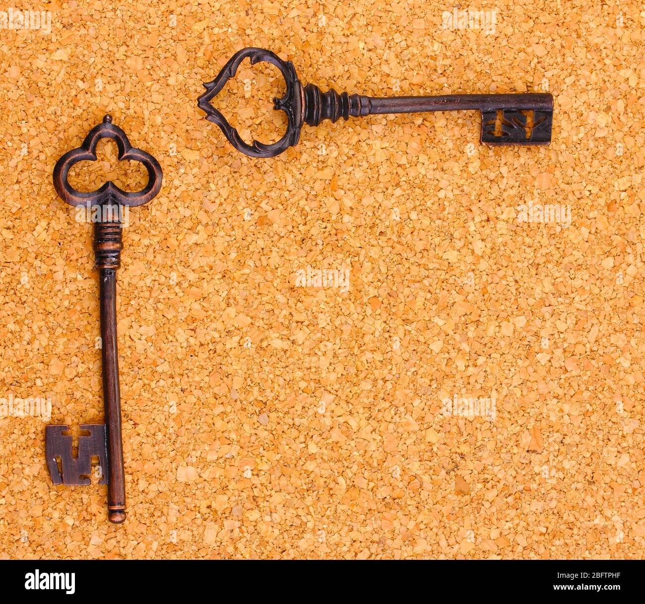 Two antique keys on cork background Stock Photo - Alamy