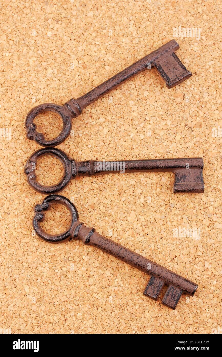 a bunch of antique keys on cork background Stock Photo - Alamy
