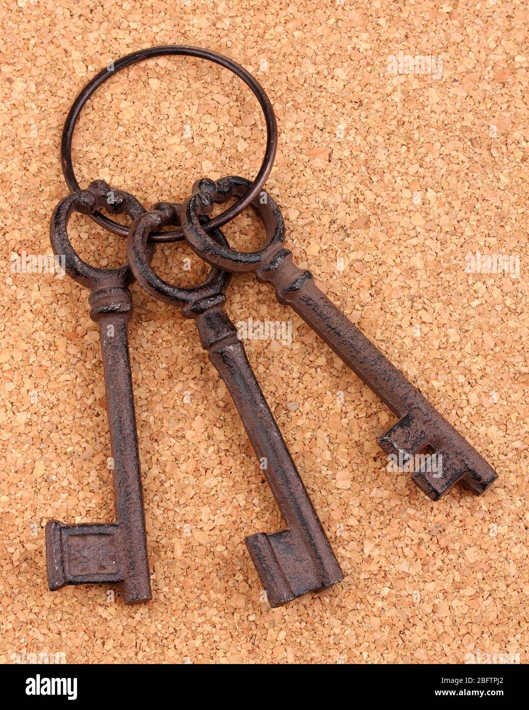 a bunch of antique keys on cork background Stock Photo - Alamy