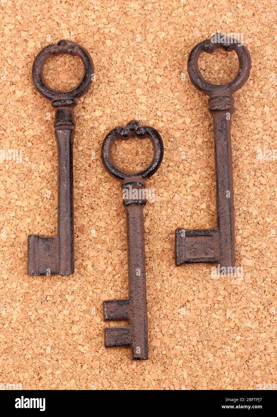 a bunch of antique keys on cork background Stock Photo - Alamy