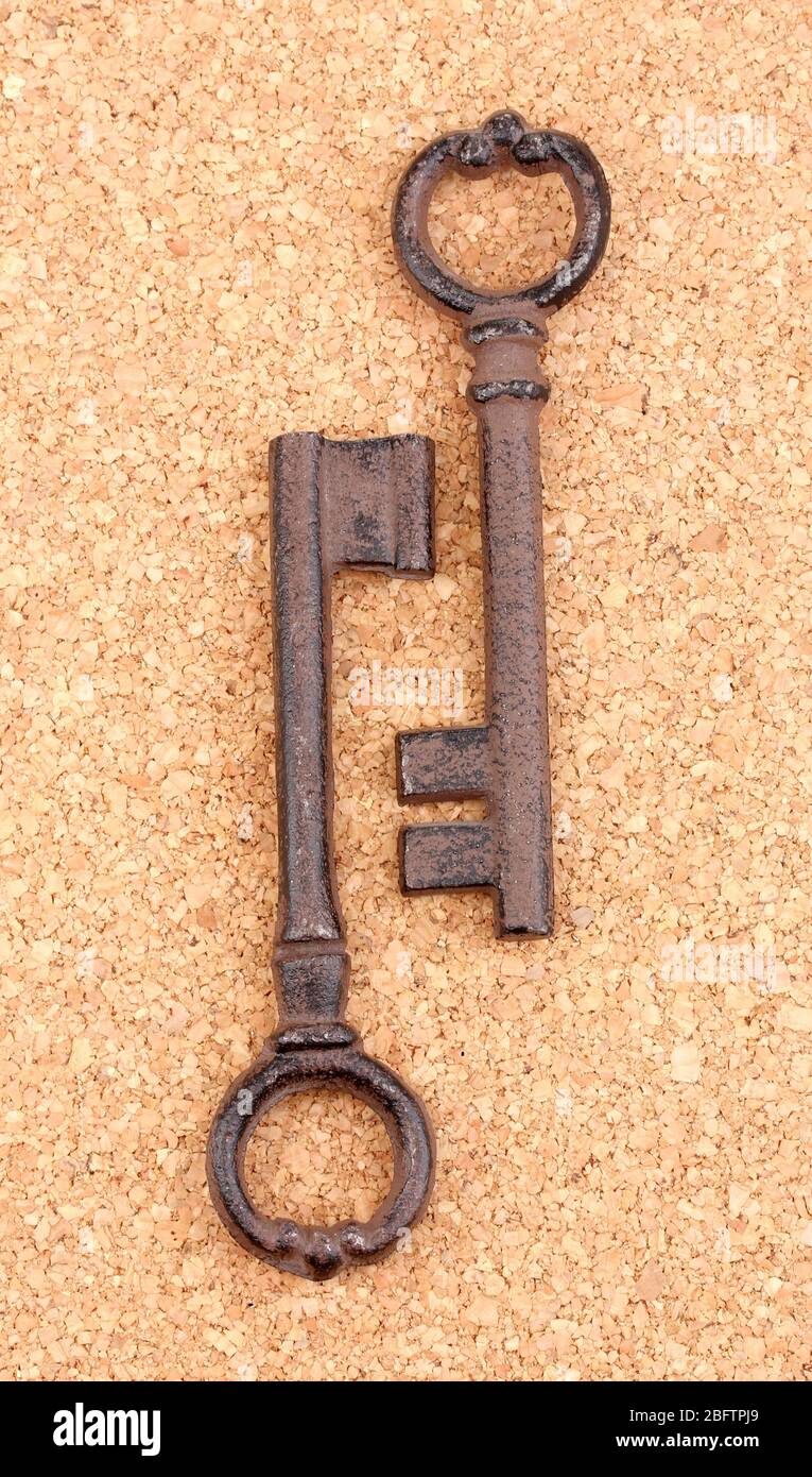 Two antique keys on cork background Stock Photo - Alamy