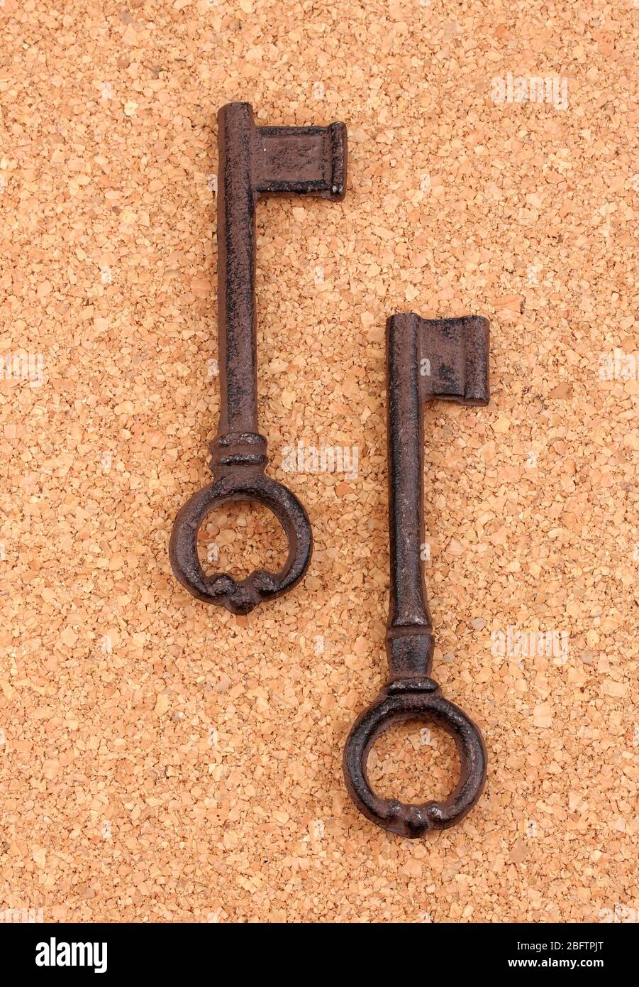 Two antique keys on cork background Stock Photo - Alamy