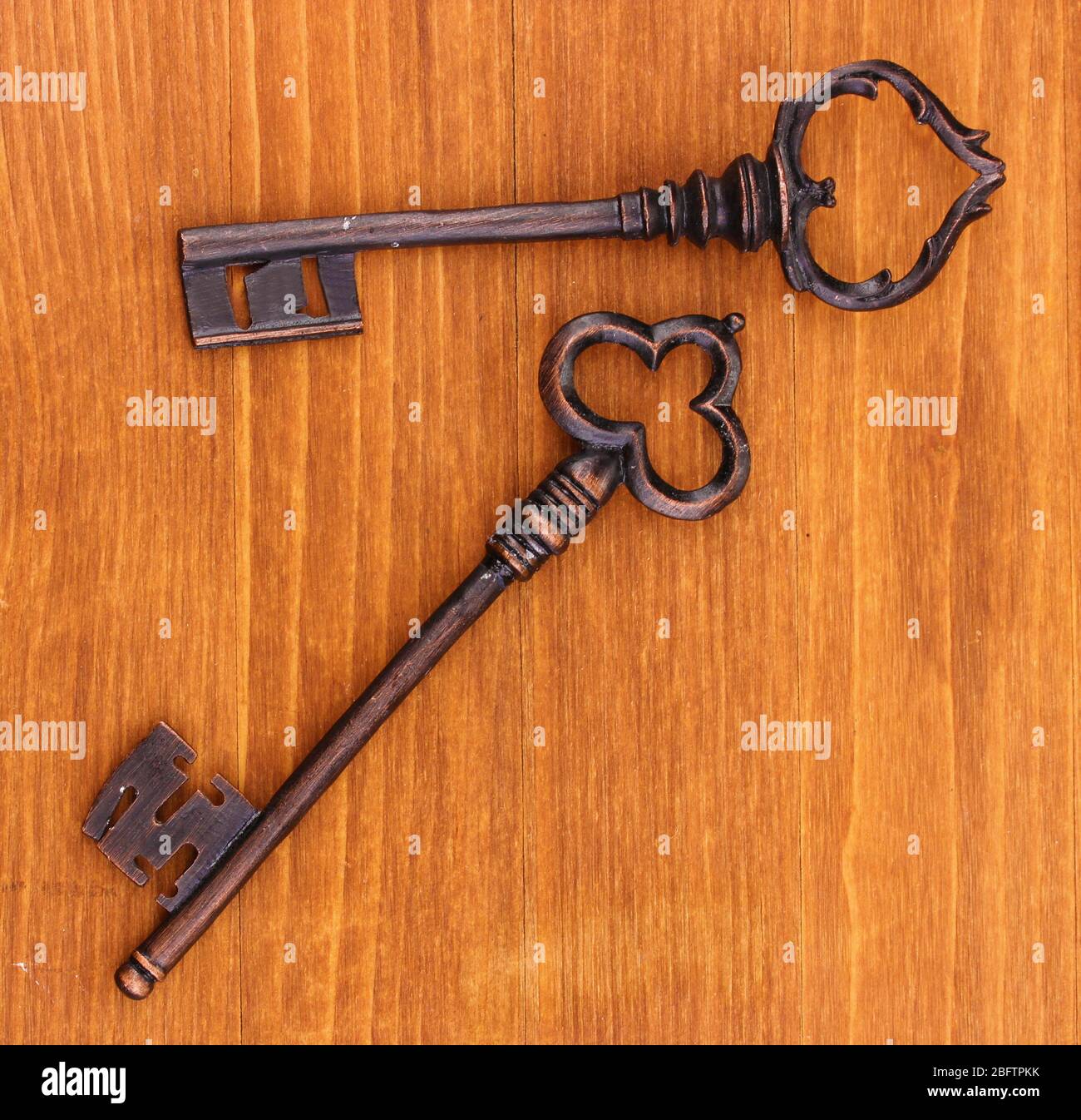 Two antique keys on wooden background Stock Photo - Alamy