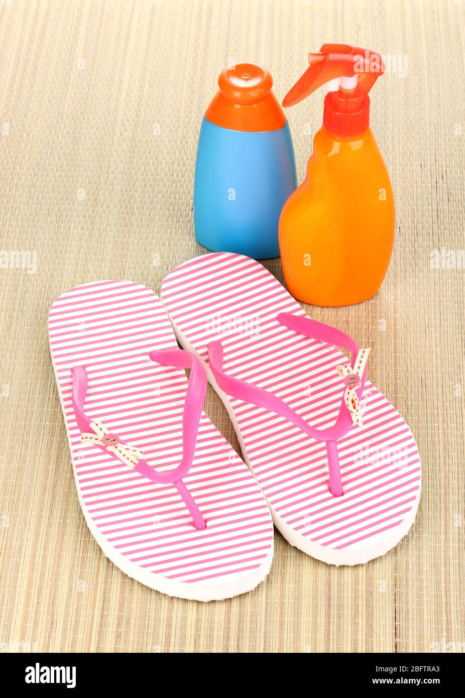 Pink beach slippers and sunscreen on mat Stock Photo - Alamy