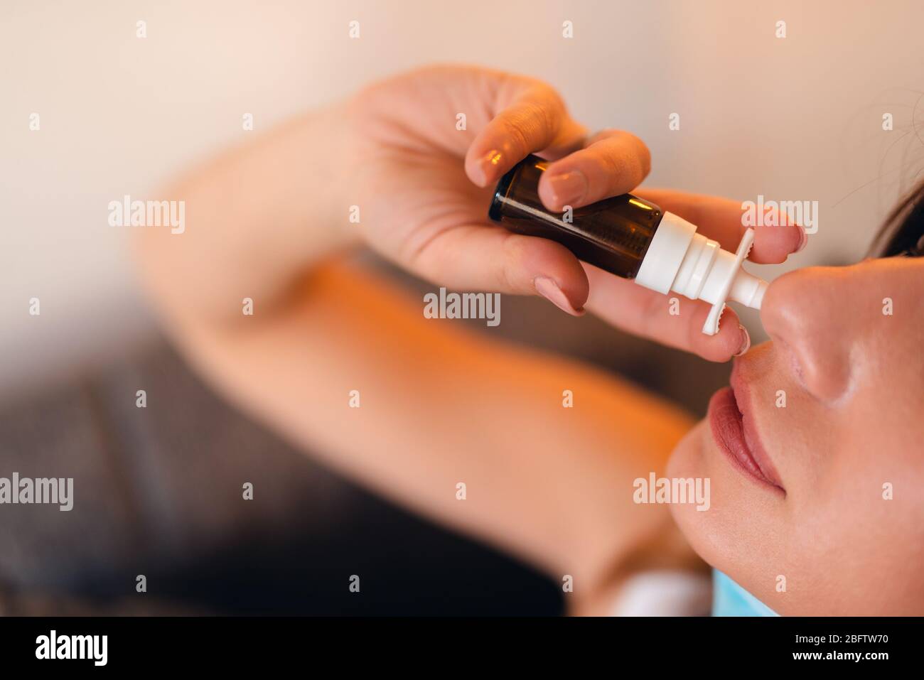 Sick caucasian girl with mask puts nose drops on during COVID - 19 ...