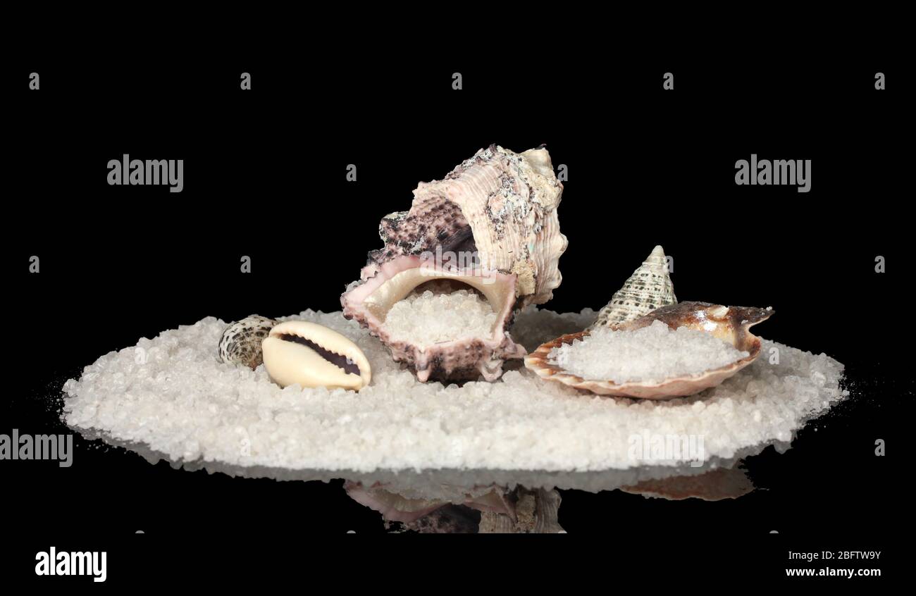 Sea Salt with shells isolated on black background Stock Photo - Alamy