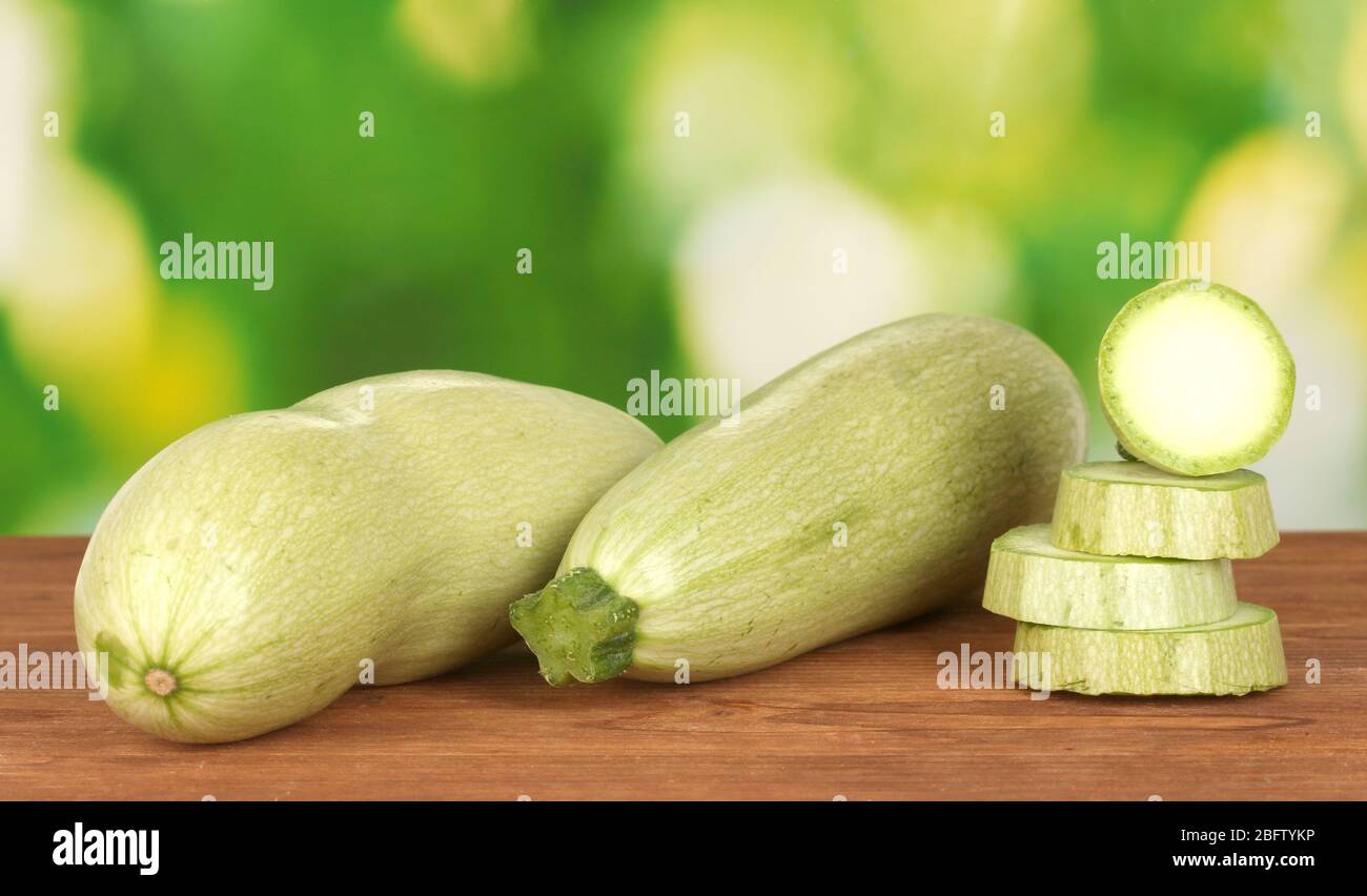 sliced squash on wooden table on green background Stock Photo - Alamy