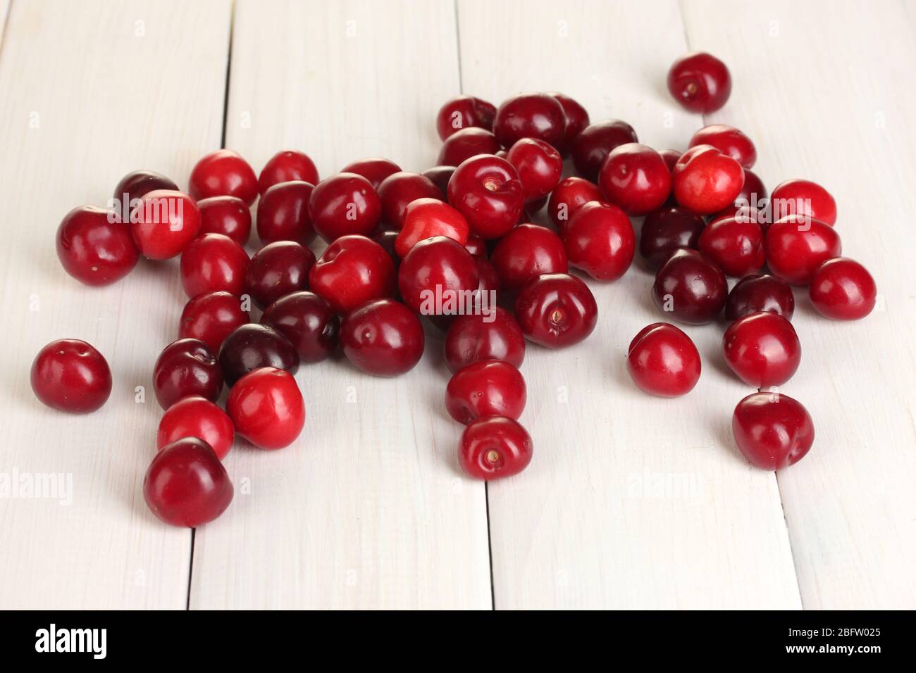 fresh cherry on white wooden table close-up Stock Photo - Alamy