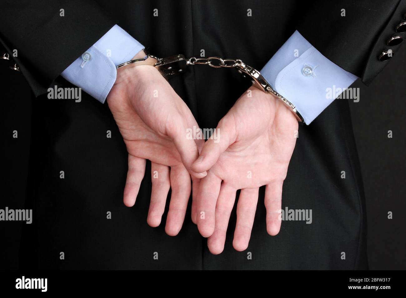 Businessman hands fettered with handcuffs Stock Photo - Alamy