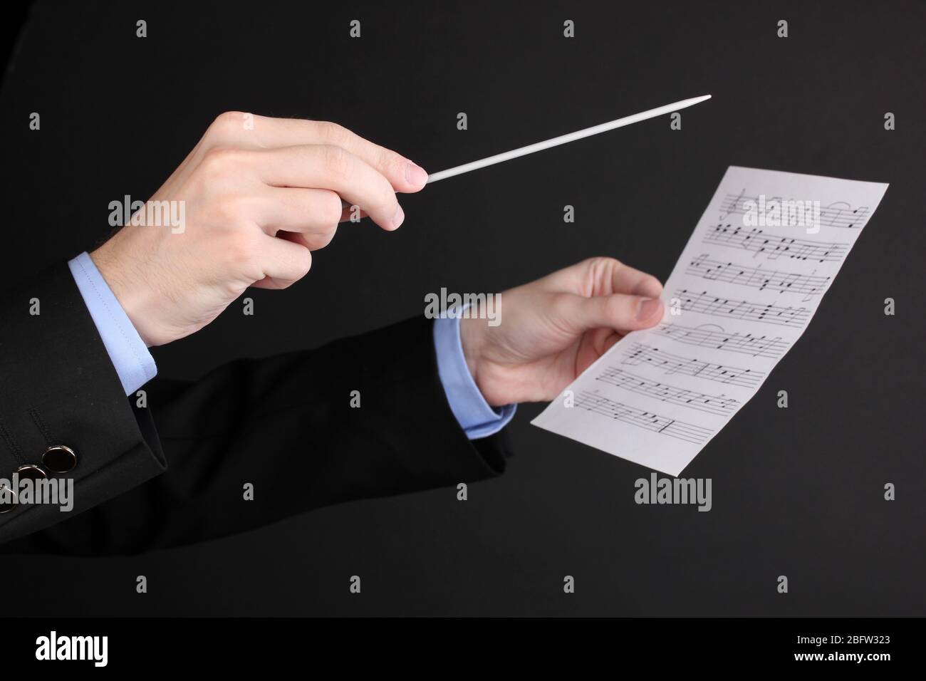 Music conductor hands with baton and notes isolated on black Stock ...