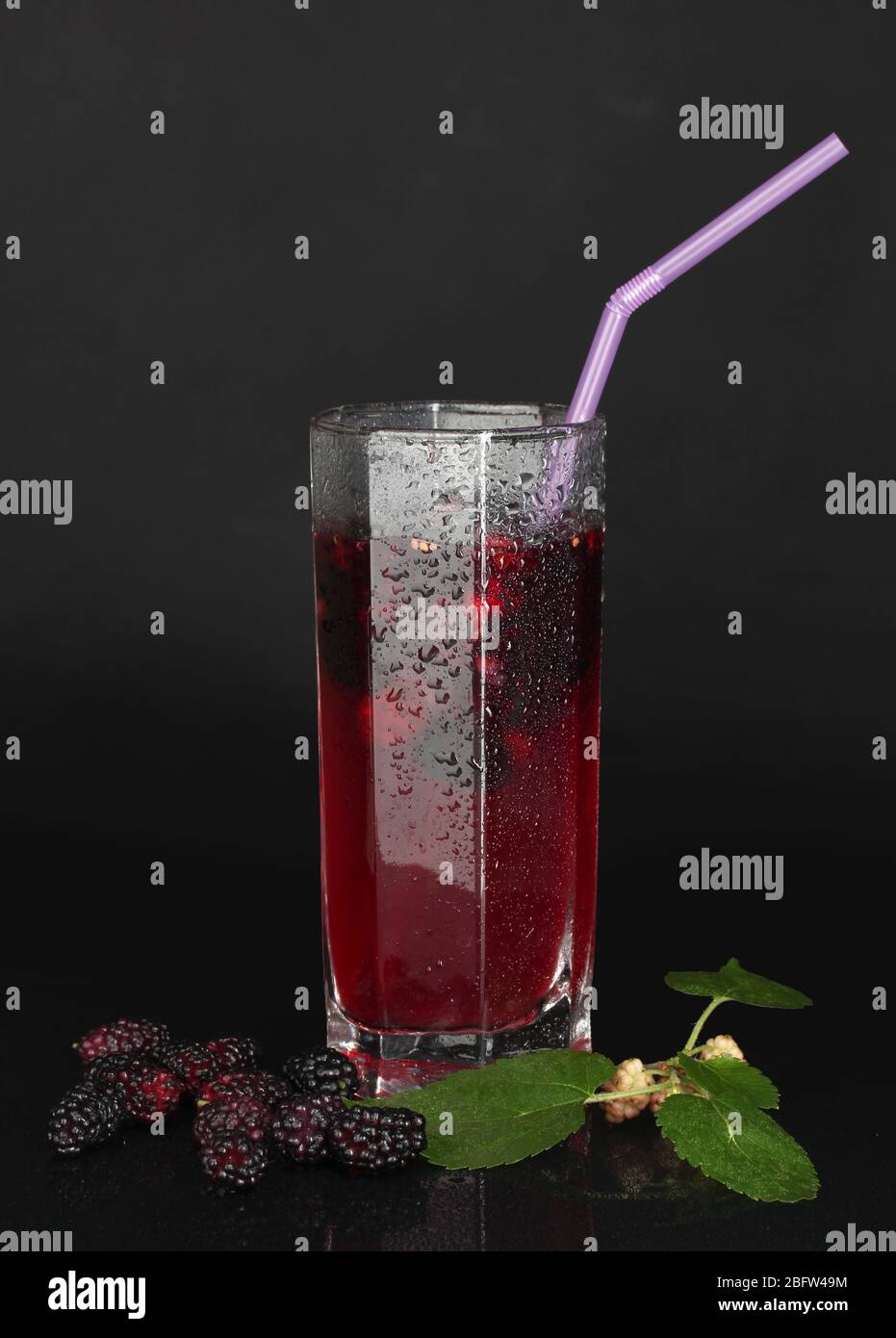 Glass of refreshing mulberry juice isolated on black background Stock ...