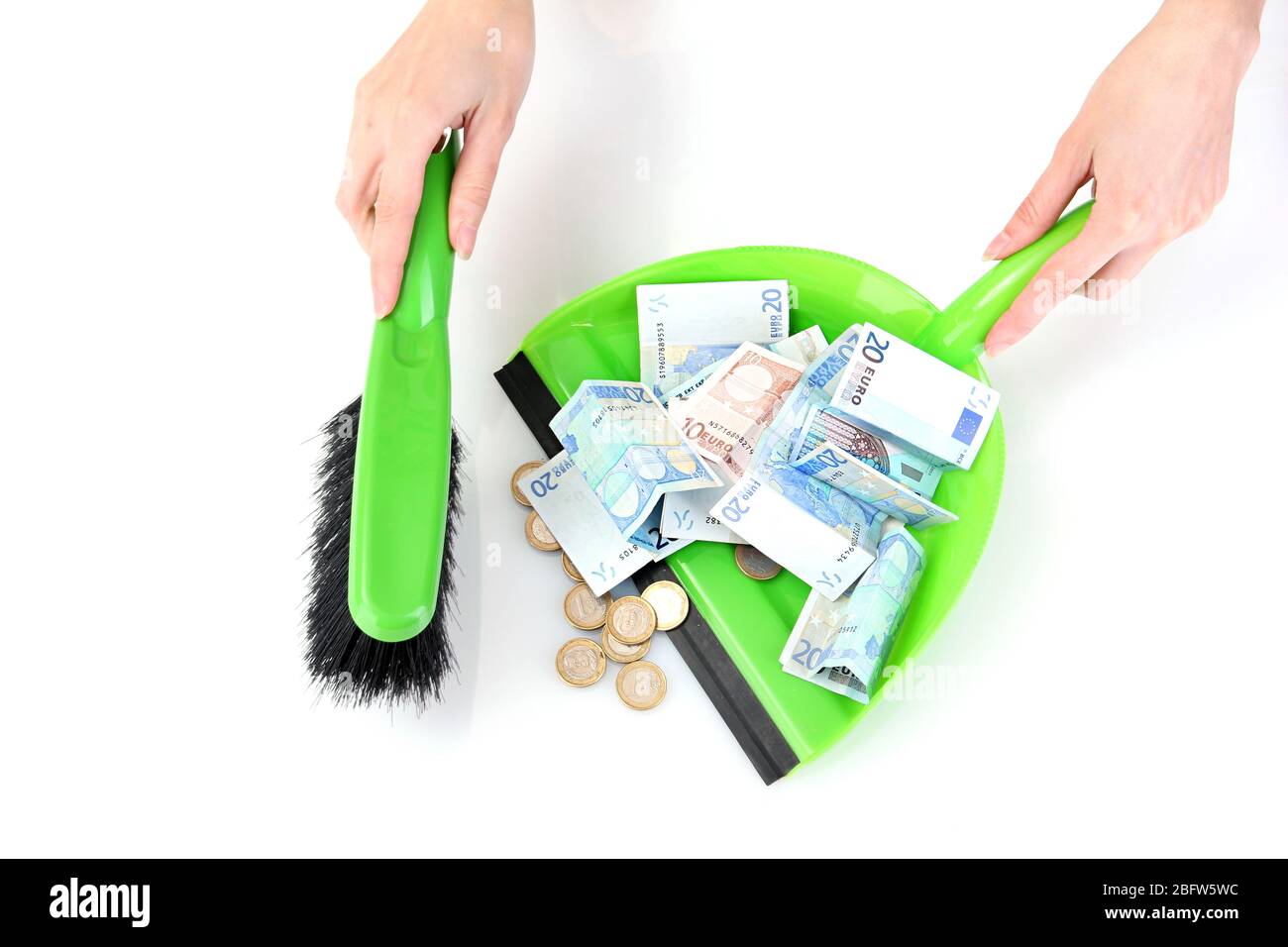 Sweeps money in the shovel on white background close-up Stock Photo - Alamy