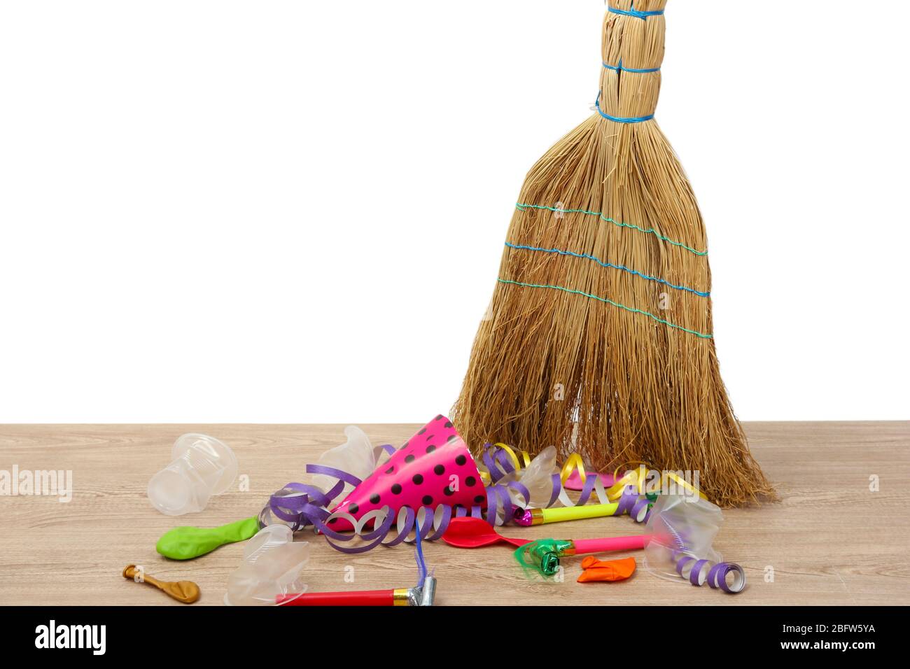 Broom sweep the trash after a party on white background close-up Stock ...