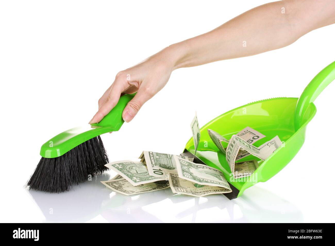 Sweeps money in the shovel on white background close-up Stock Photo - Alamy
