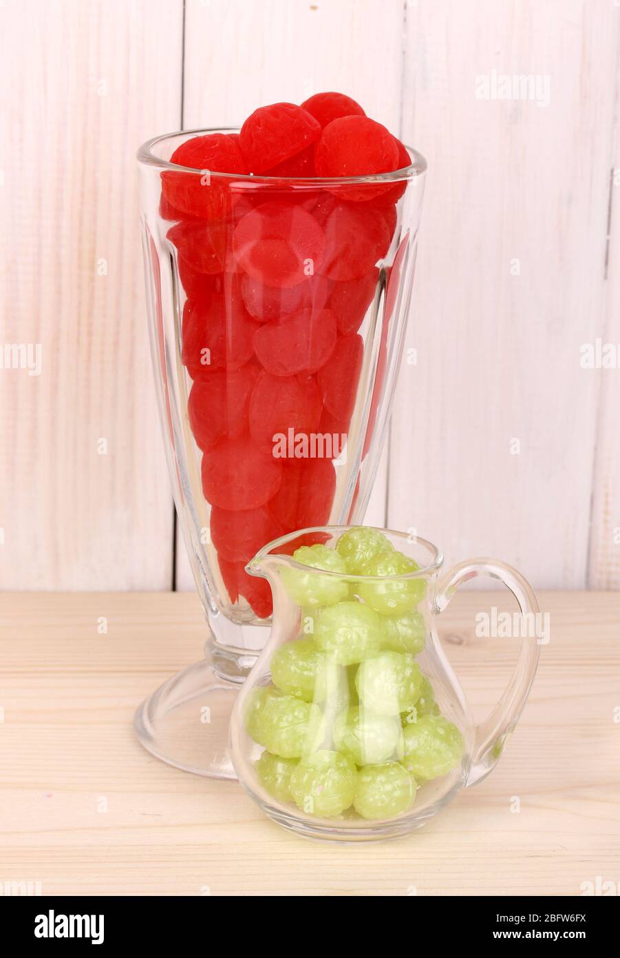 Color candies in glasses on wooden background Stock Photo - Alamy