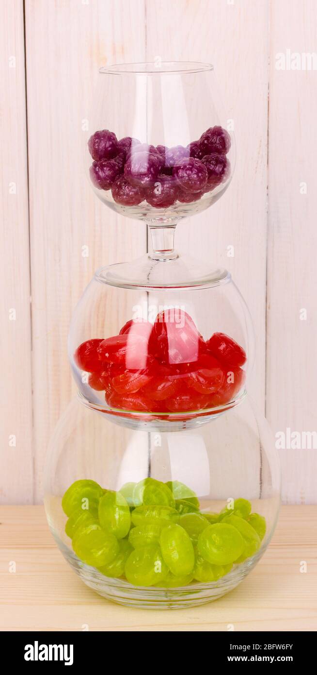 Color candies in glasses on wooden background Stock Photo - Alamy