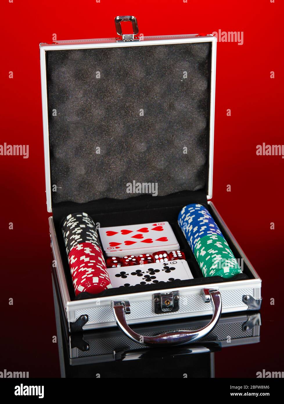 Poker set in metallic case on bright red background Stock Photo - Alamy